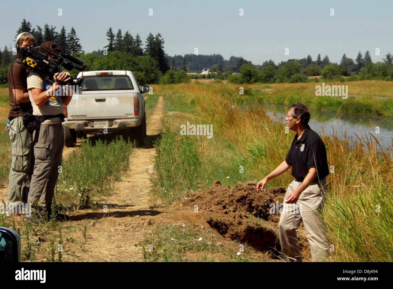 A film crew working in a natural setting, capturing outdoor scenes. The ...