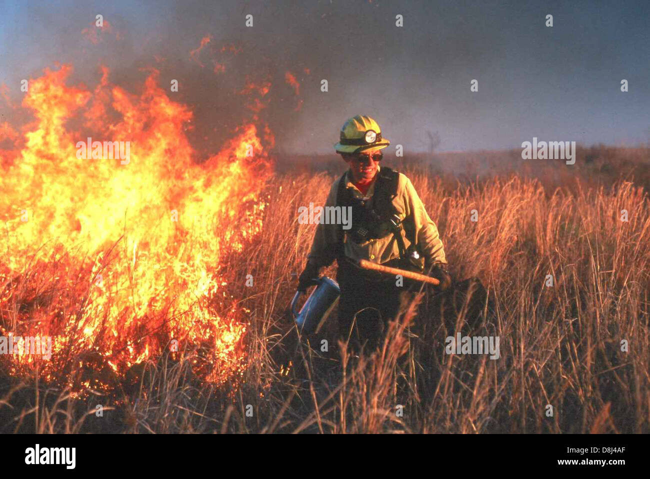 A firefighter actively working at the scene of a fire, equipped with ...