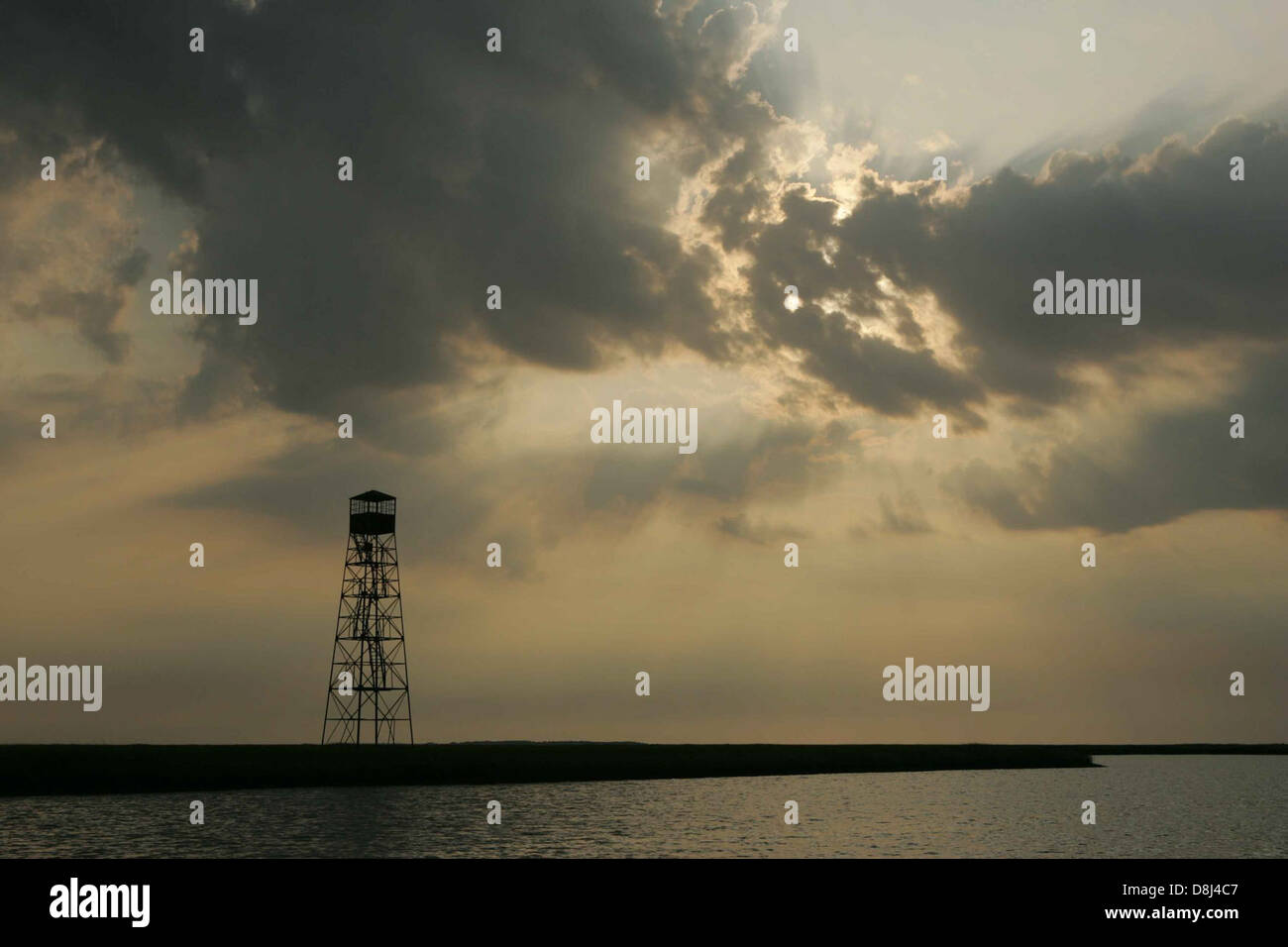 A fire tower positioned on the coast at dusk, capturing the transition ...