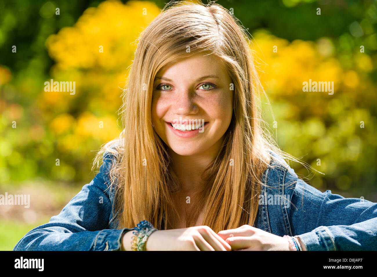 Smiling blonde teenage girl looking at camera outdoors Stock Photo - Alamy