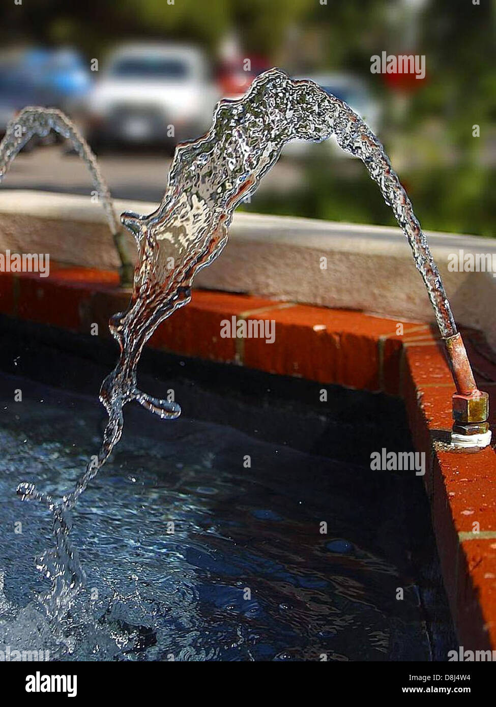 A fountain with a water spout, where water jets upward and cascades ...