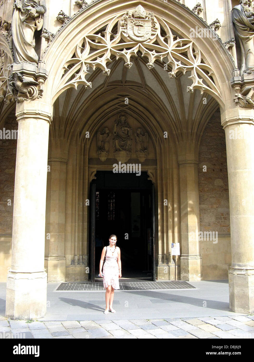 A Gothic church gate stands tall and intricate, with pointed arches and ...