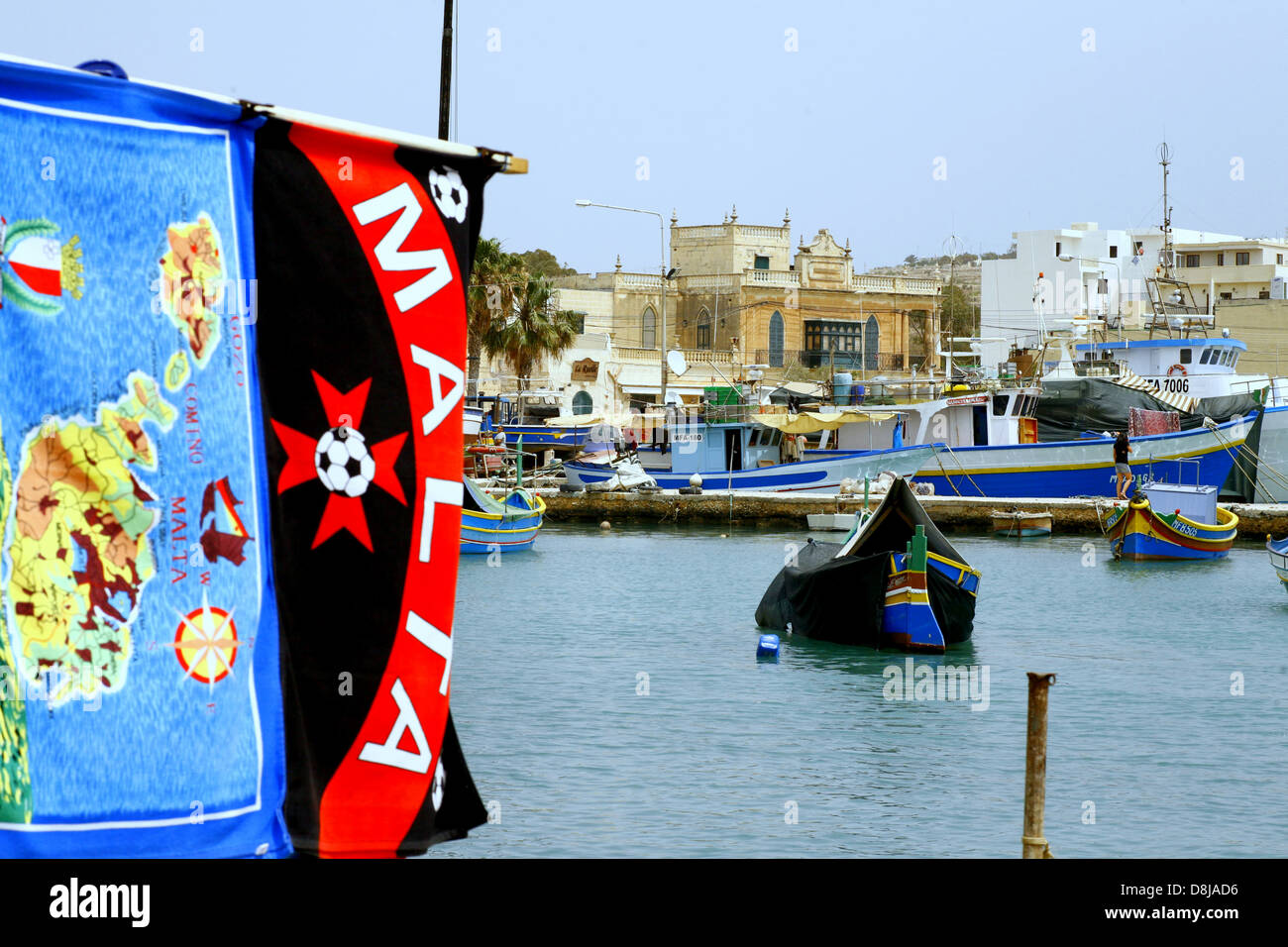 Souvenir towels for sale on a market stall with the harbor of ...