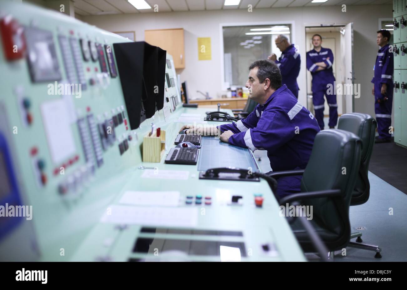 A crew member works in the engine control room of the container ship ...
