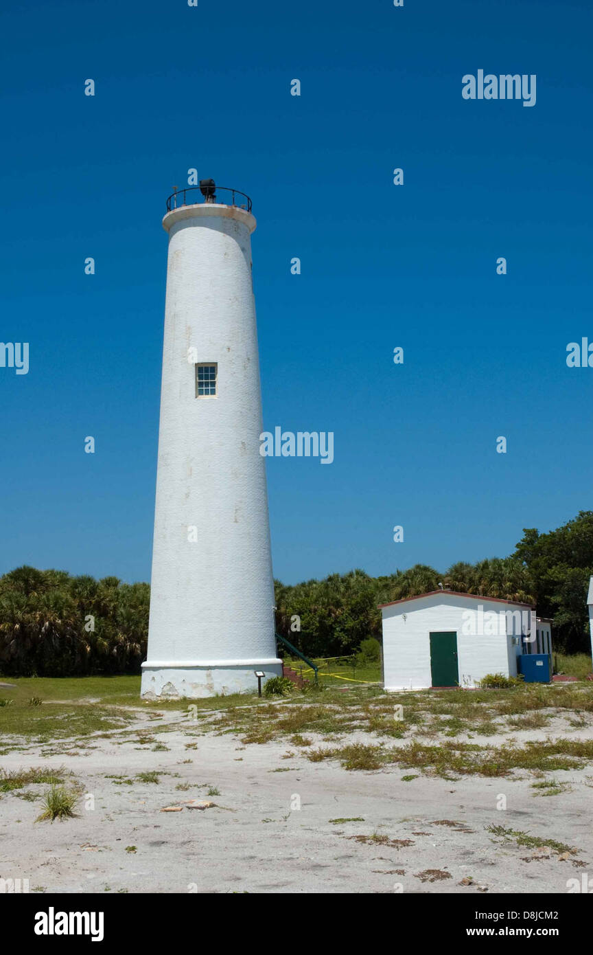 The photograph features a white lighthouse tower standing tall against ...