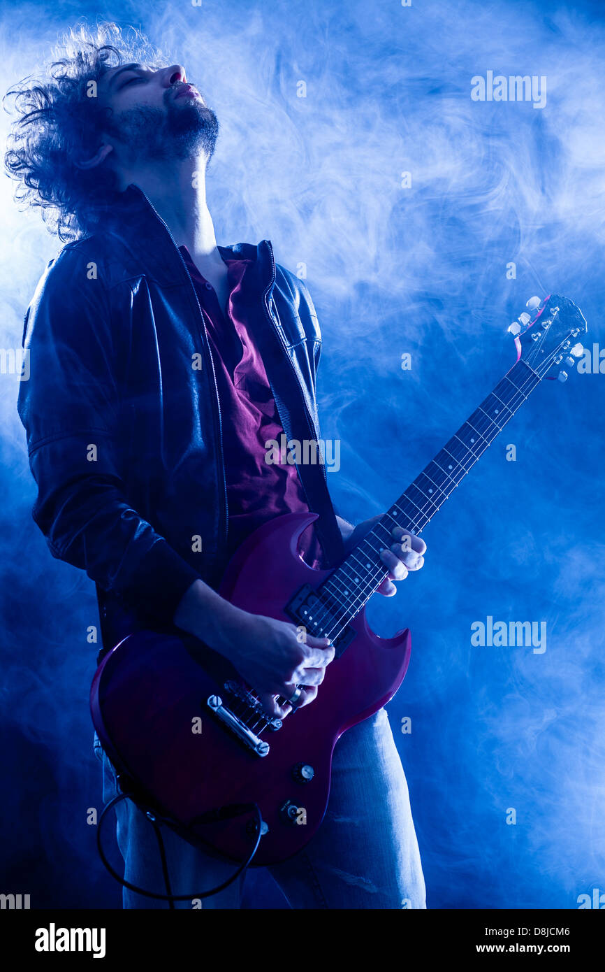 Young man playing electric guitar with woman wearing inline skate in ...