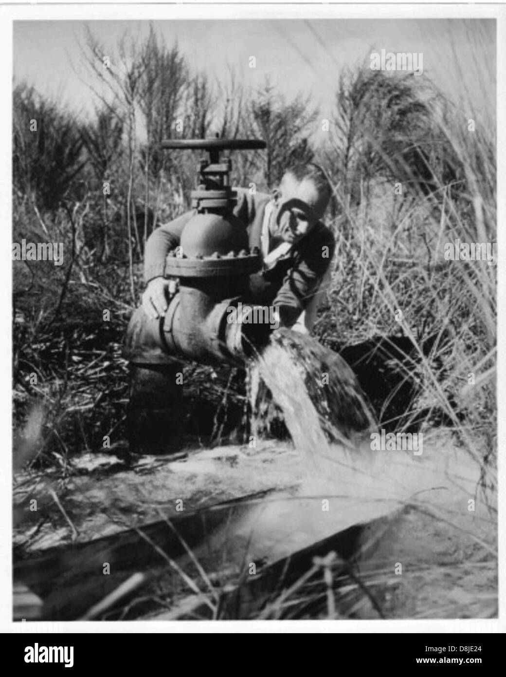A man inspects the water outlet that supplies fresh water to a ...