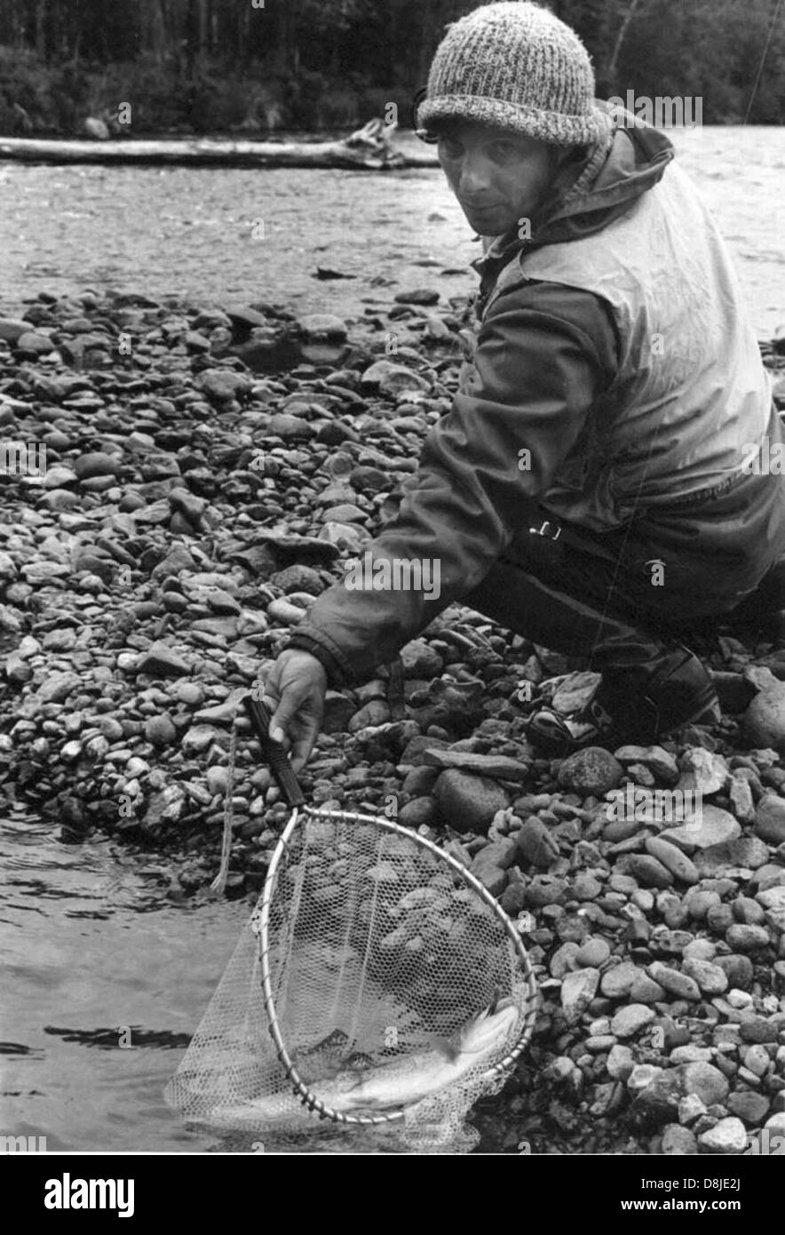 A vintage black and white photograph of a man fishing, capturing a ...