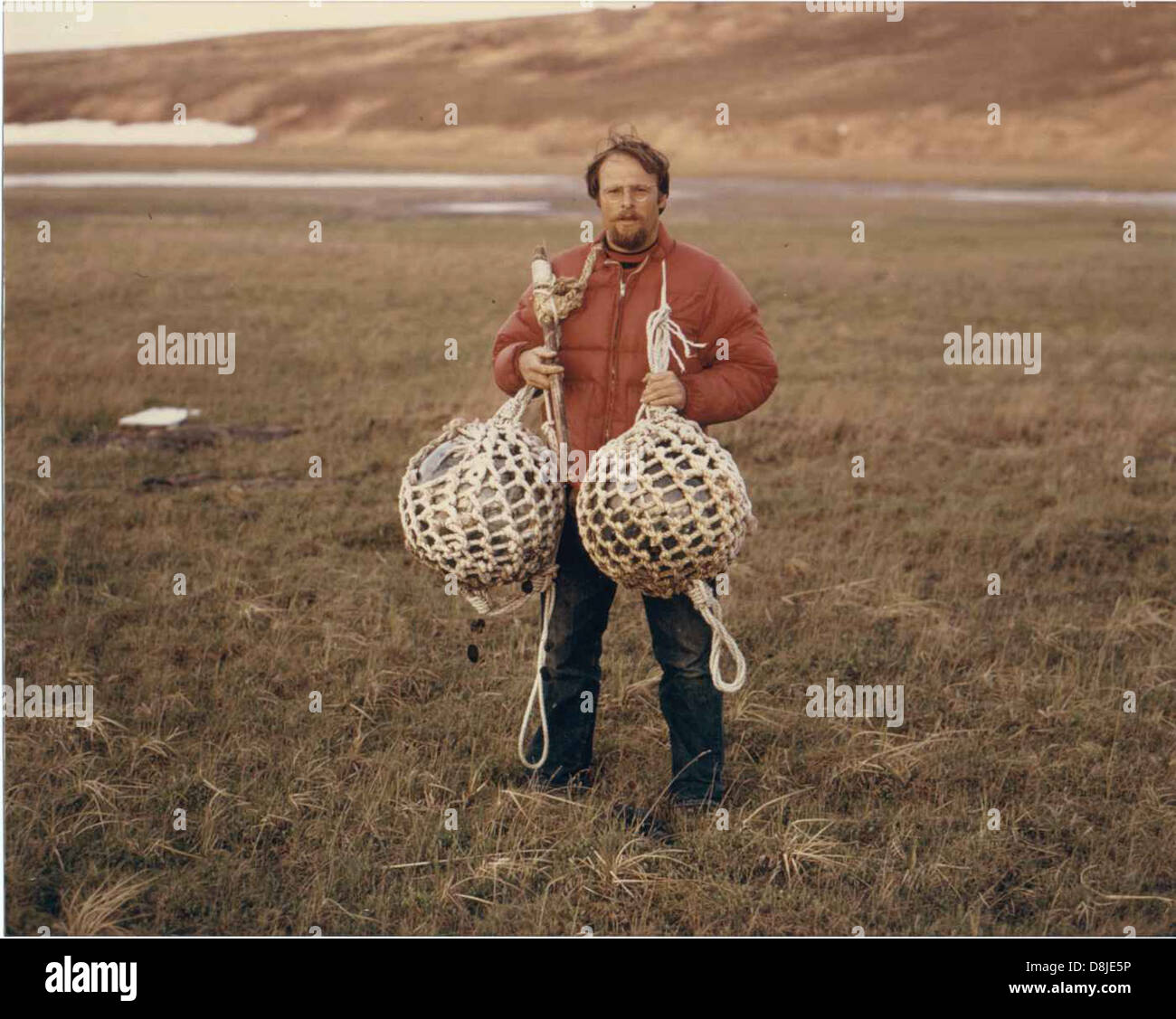 A man is seen holding two large glass Japanese fishing floats, known ...