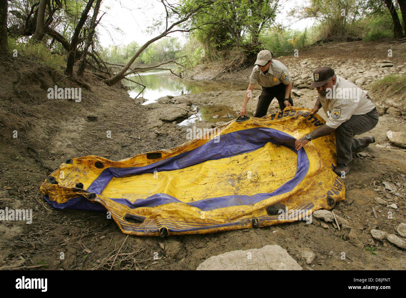Two men navigate a river in a small raft boat, demonstrating teamwork ...