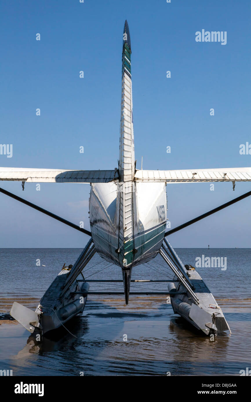 Rear view of the tail and fuselage of a small sea plane beached along ...