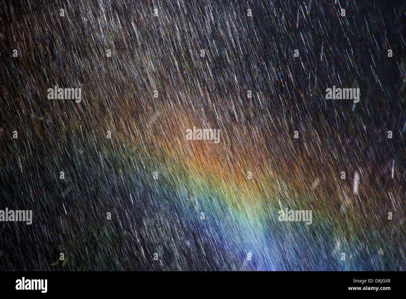 Light refracting causing a rainbow effect on water spraying from a ...