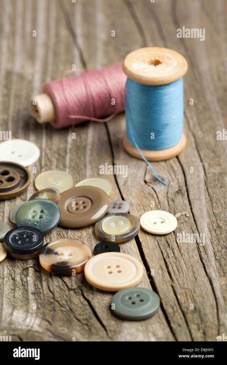 Spools of threads and buttons on old wooden table Stock Photo - Alamy