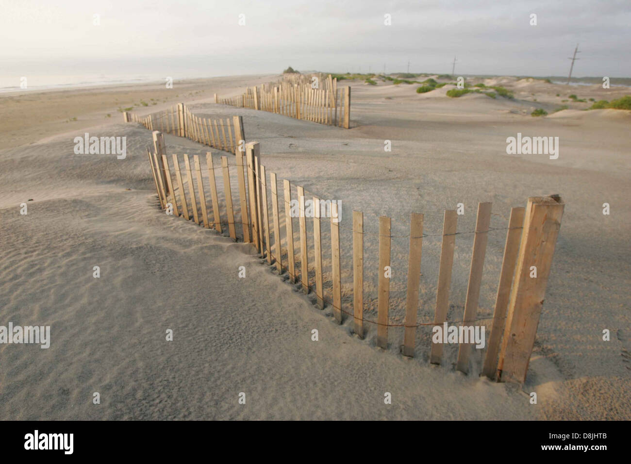This image features a well-maintained wooden fence on a beach ...