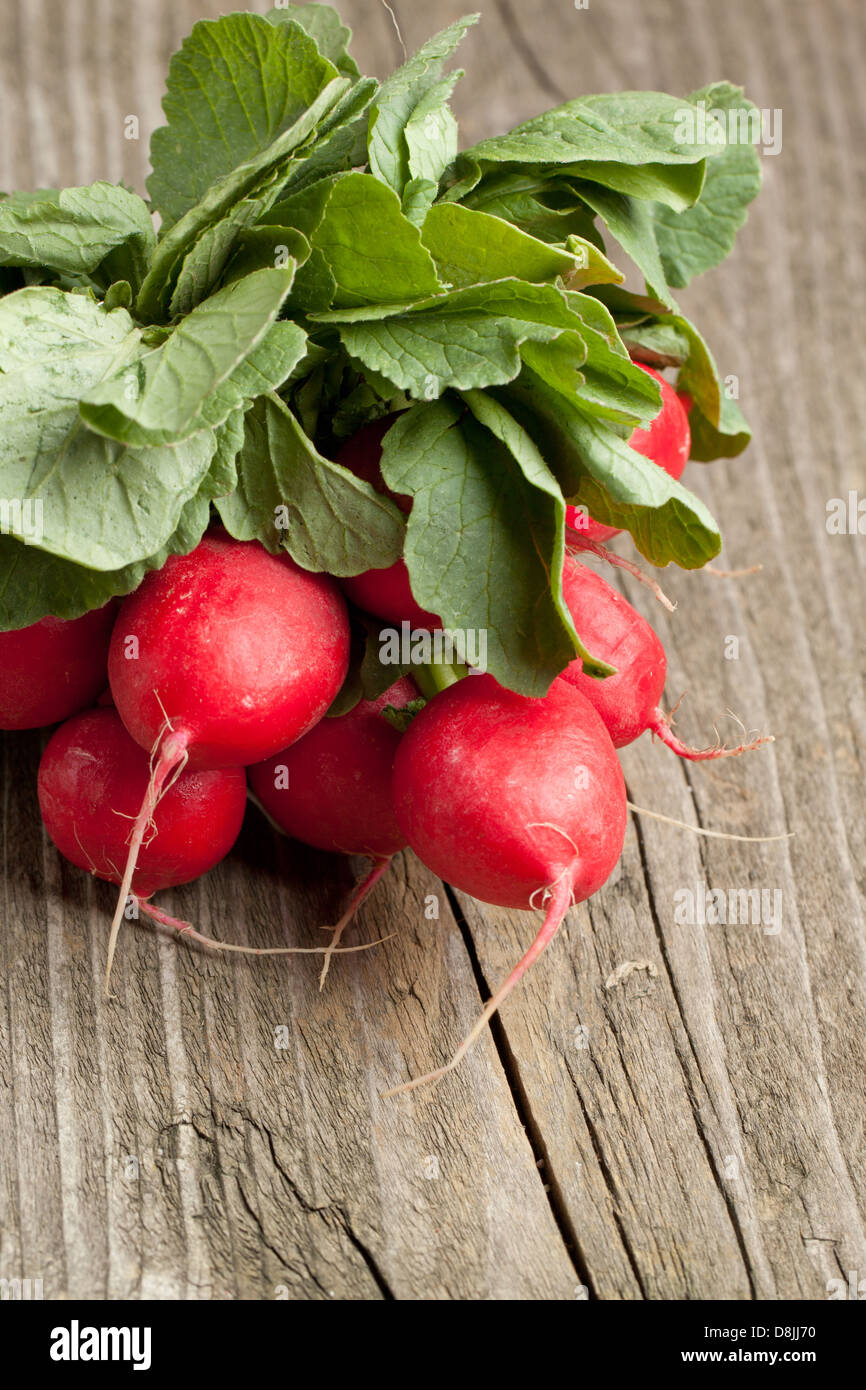 Bunch of fresh radishes on old wooden table Stock Photo - Alamy