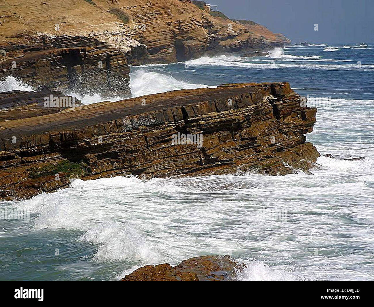 A dramatic view of ocean cliffs overlooking the sea, with waves ...