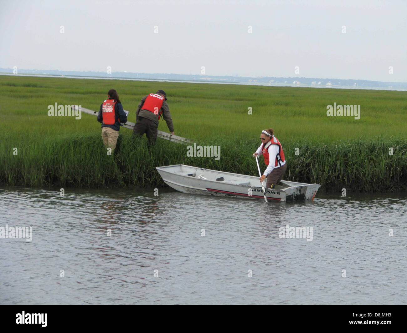 A stock photo of a person stepping out of a boat and onto a grassy area ...