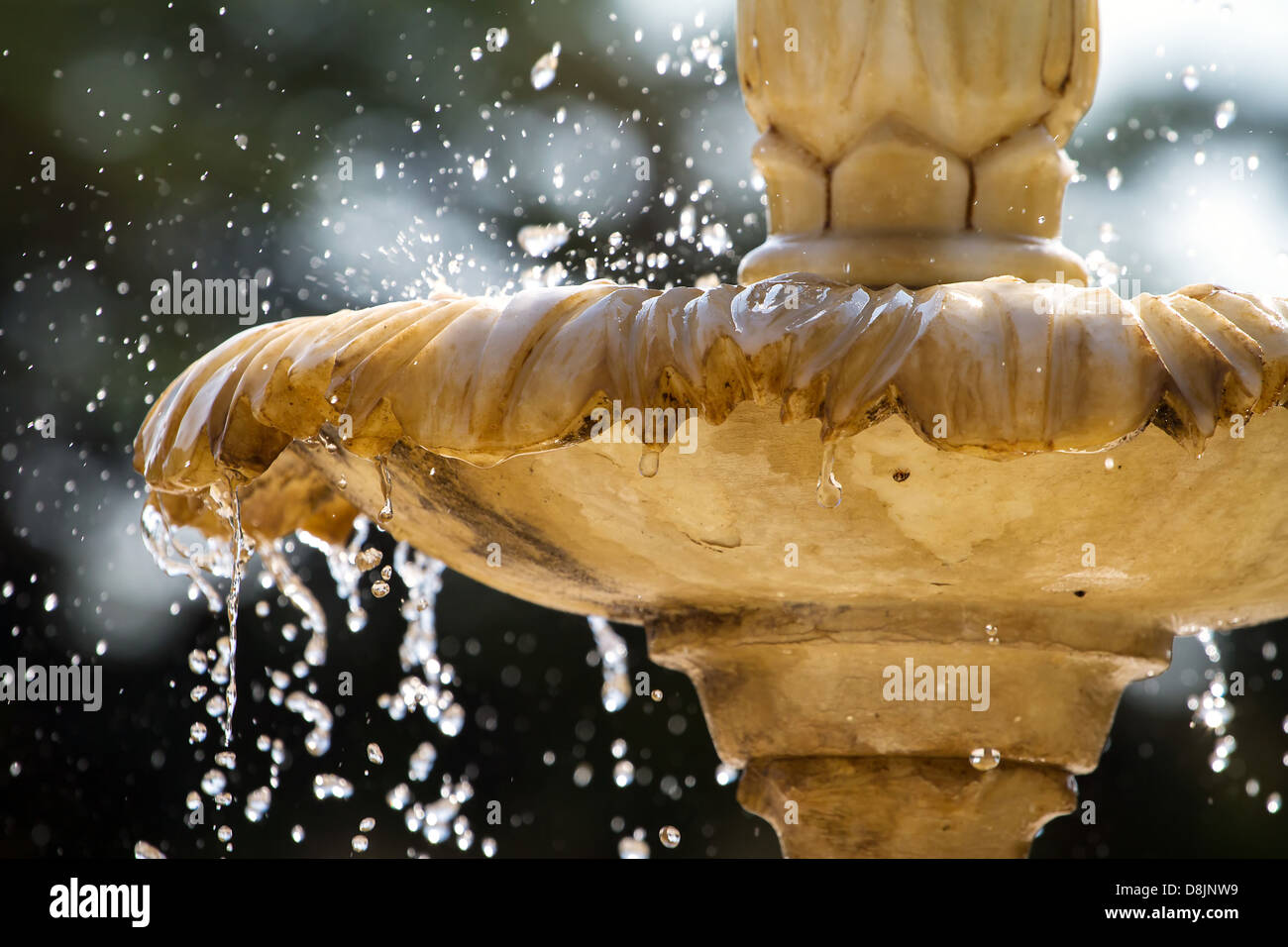 Close-up of an old stone fountain with dripping water and blurred ...