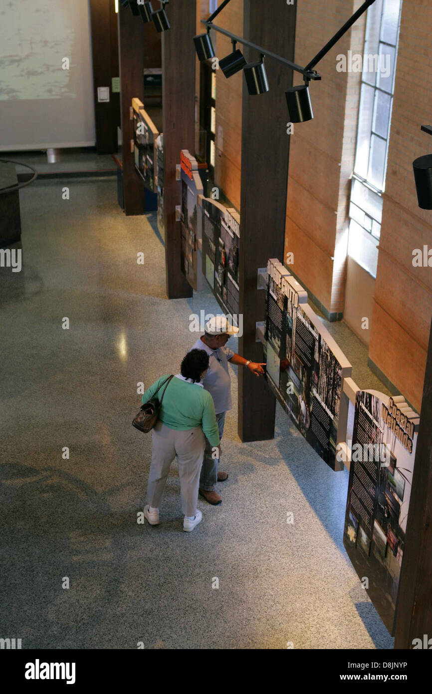 A group of people inside a building, observing a wall. The scene ...