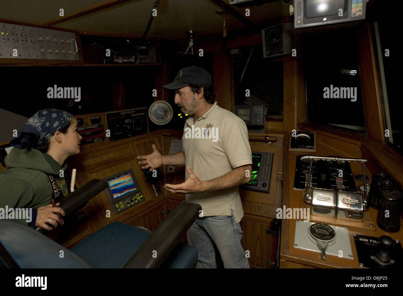 A group of people talking on a ship deck, likely enjoying a leisurely ...