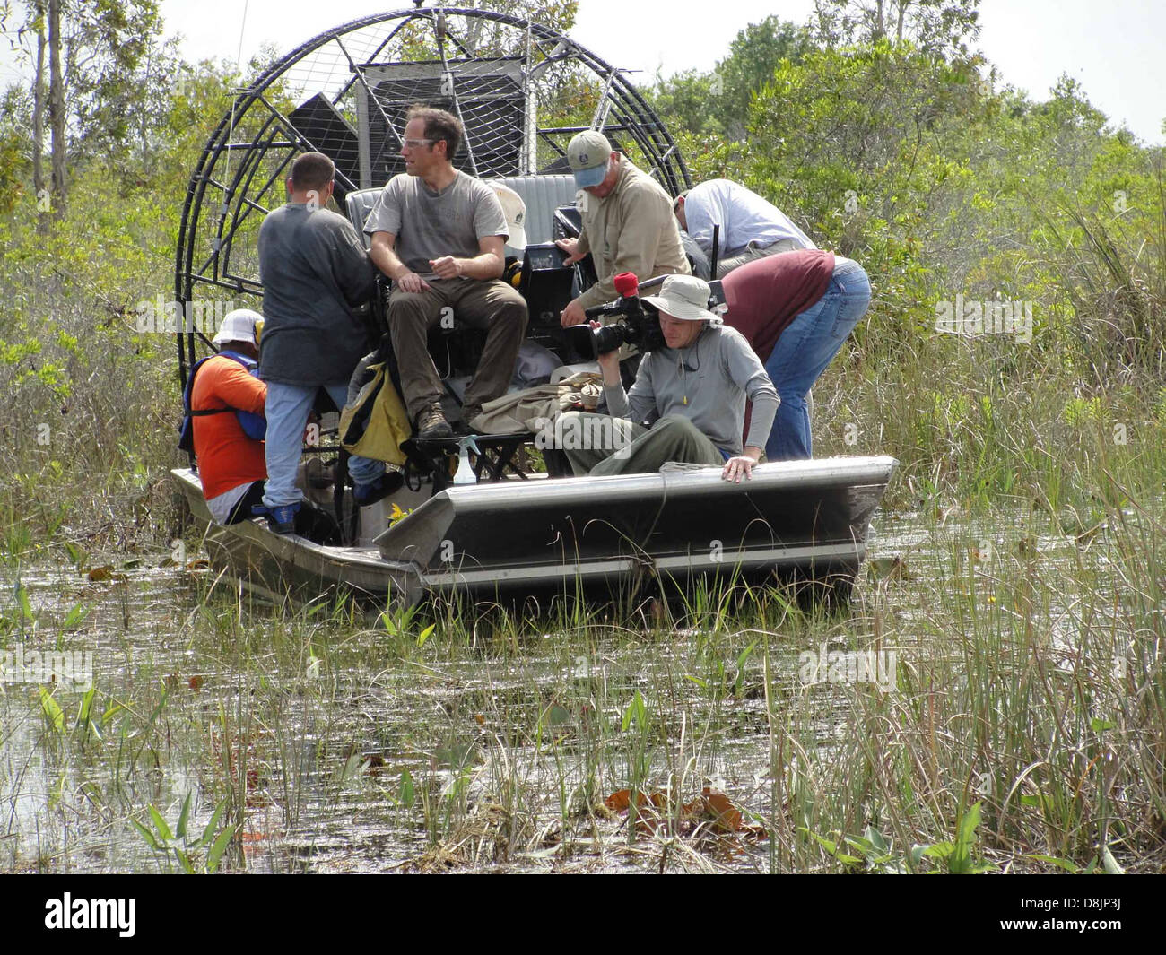 A group of people navigates through a swamp on a wind-powered boat ...