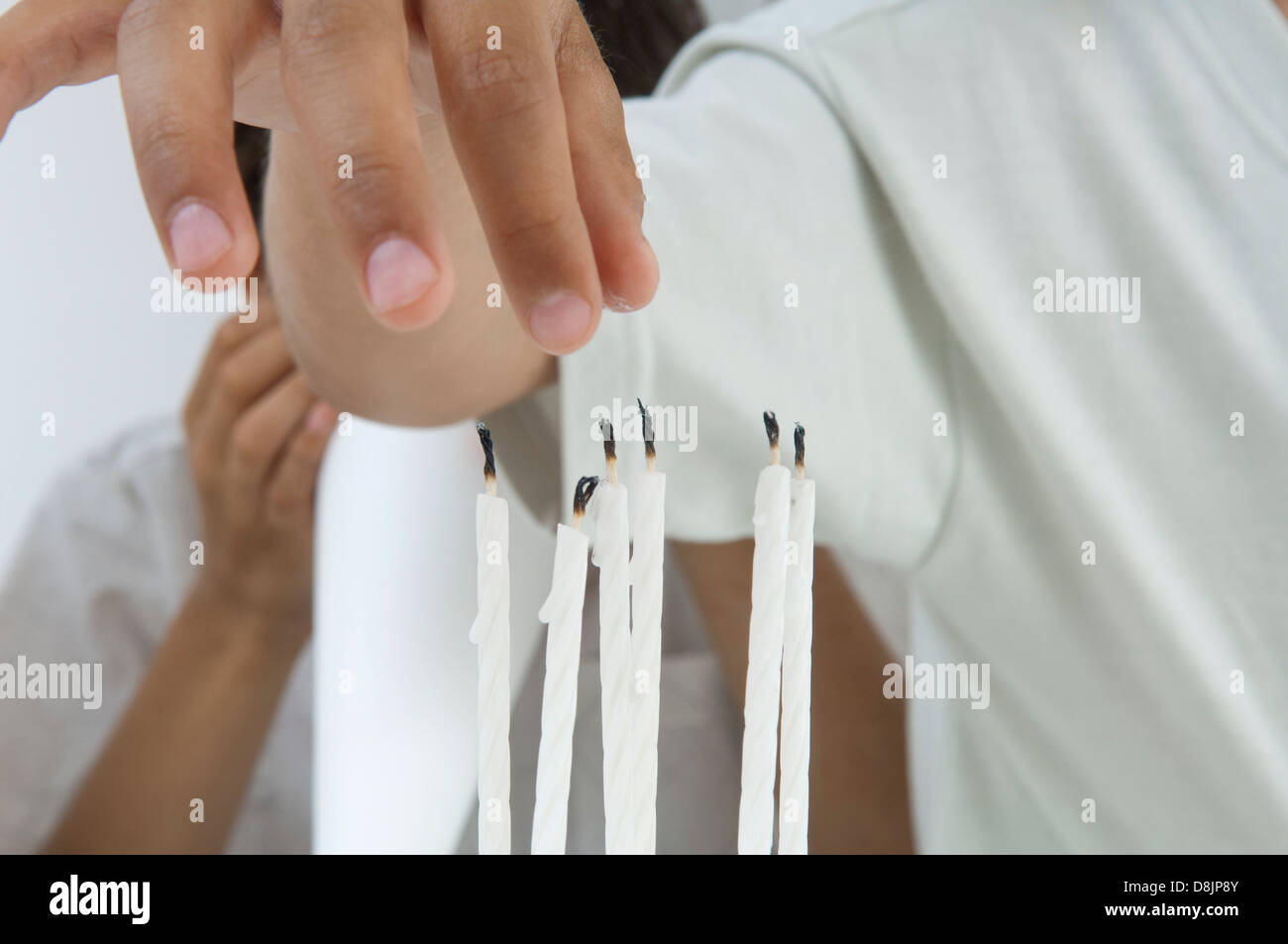 Boy's hand over blown out candles Stock Photo - Alamy