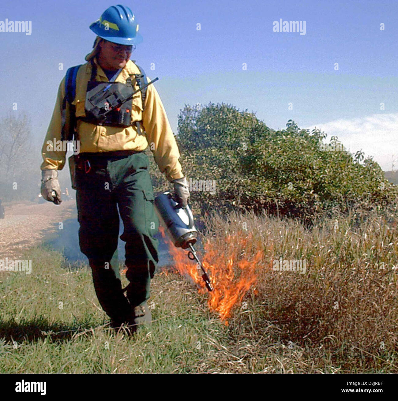 Personnel conduct controlled fire operations, managing a fire for ...