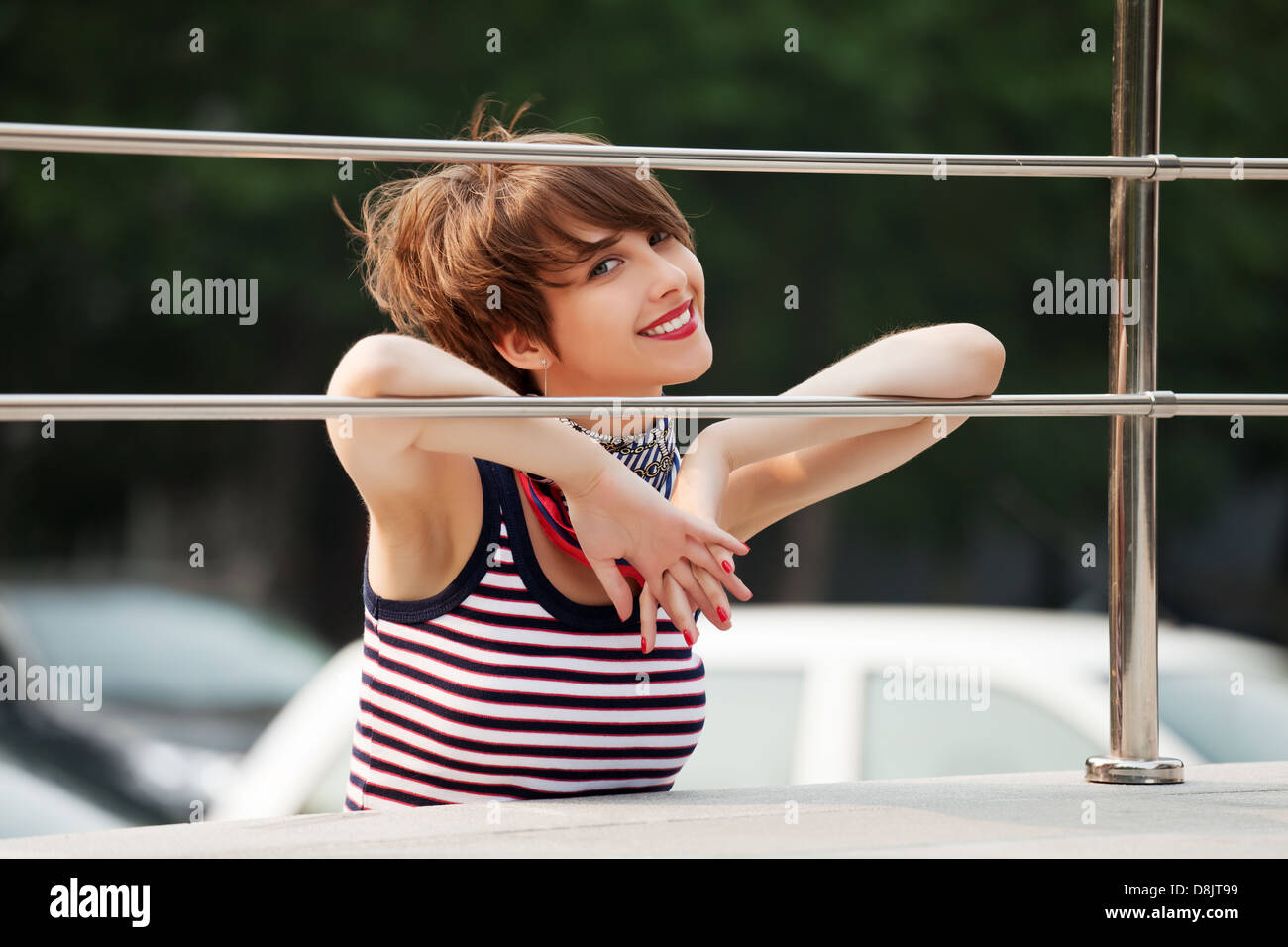 Happy young woman against a car parking Stock Photo - Alamy