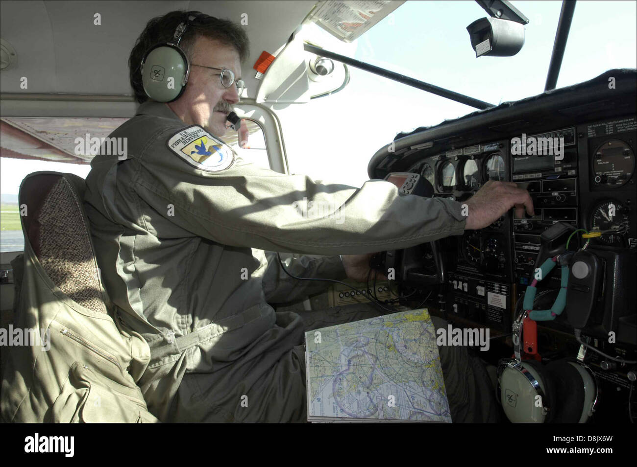 A pilot performing a pre-flight check inside the cockpit of an aircraft ...