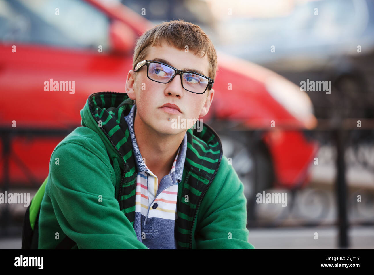 Young man sitting against a city traffic Stock Photo - Alamy