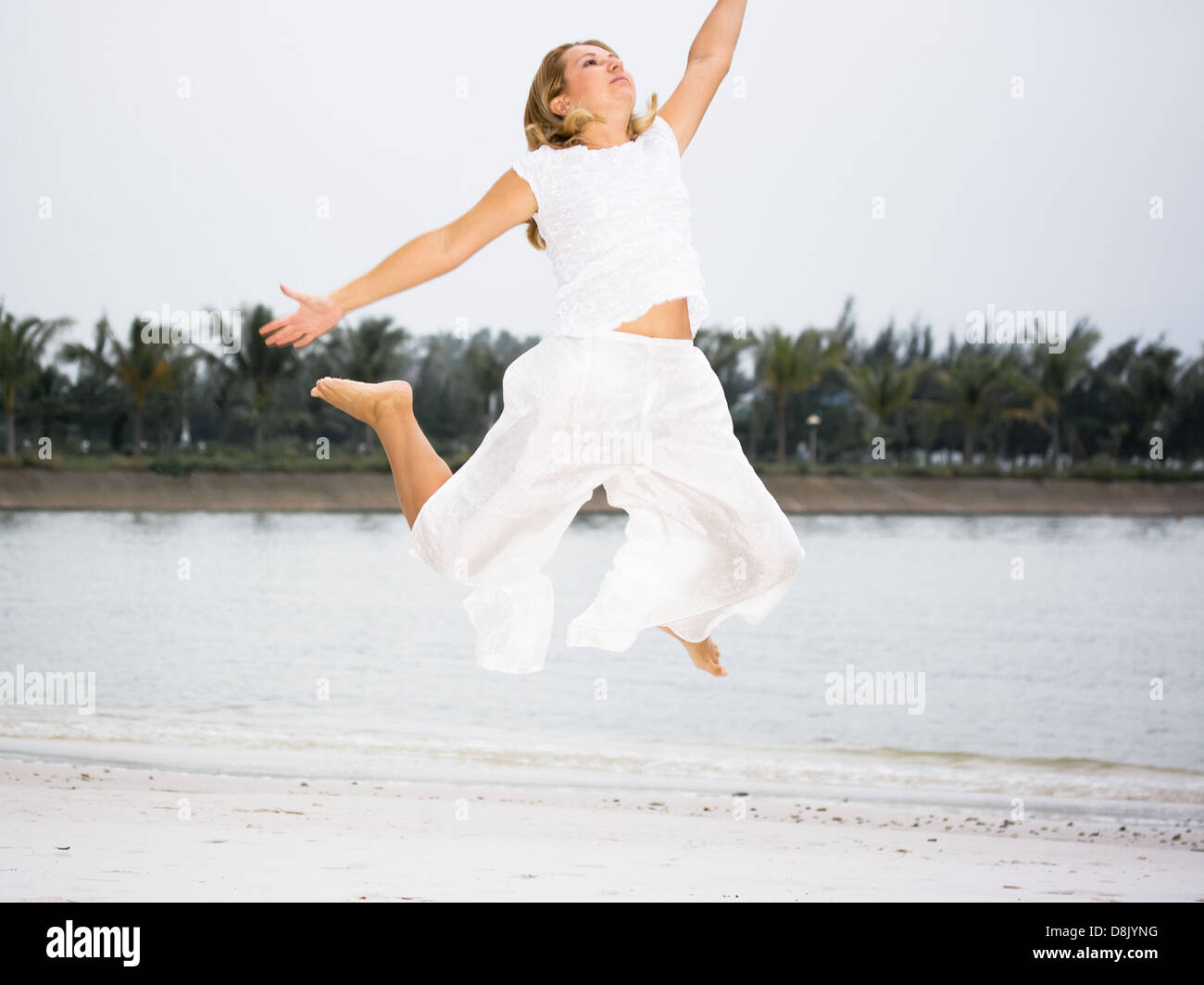 Woman jumping on the beach Stock Photo - Alamy