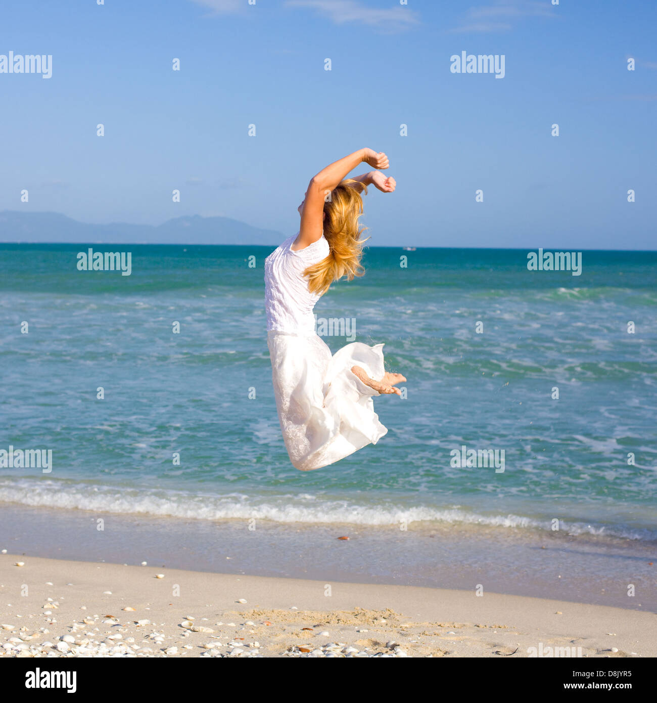 Woman jumping on the beach Stock Photo - Alamy