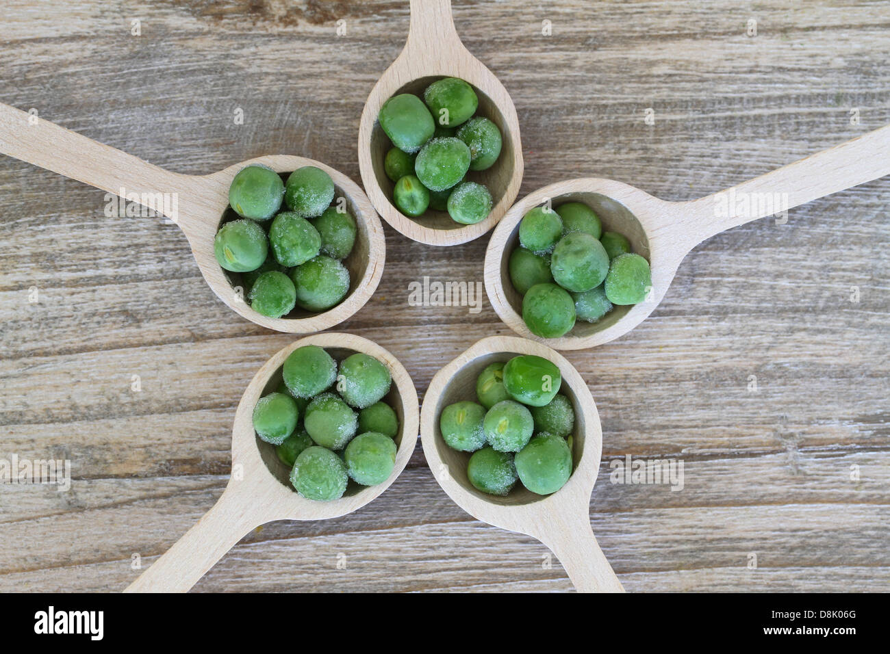 Frozen green peas on wooden spoons laid out in circle Stock Photo - Alamy