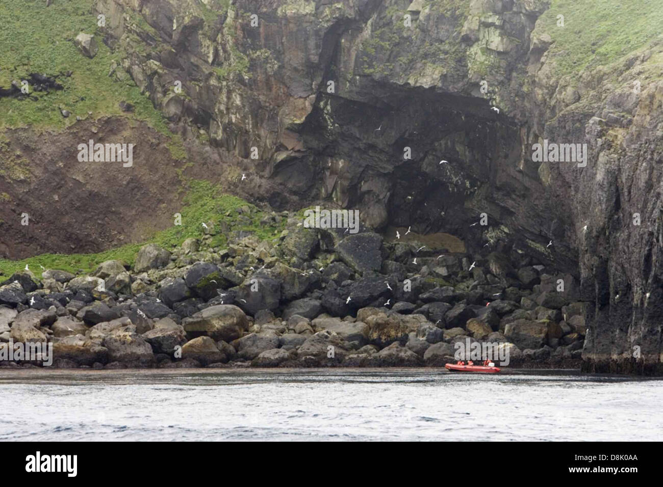 A recreational boat traveling along steep cliffs, providing a scenic ...