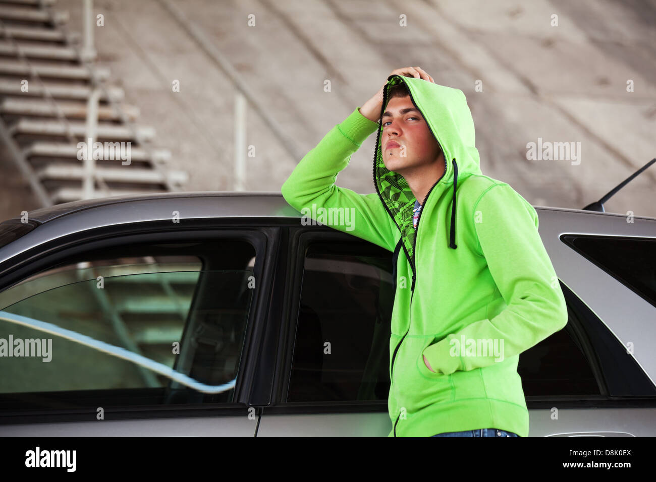 Young man standing against a car Stock Photo - Alamy
