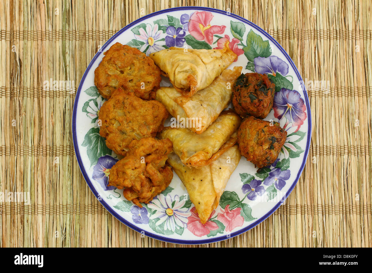 Selection of Indian vegetarian starters on vintage plate on bamboo mat ...