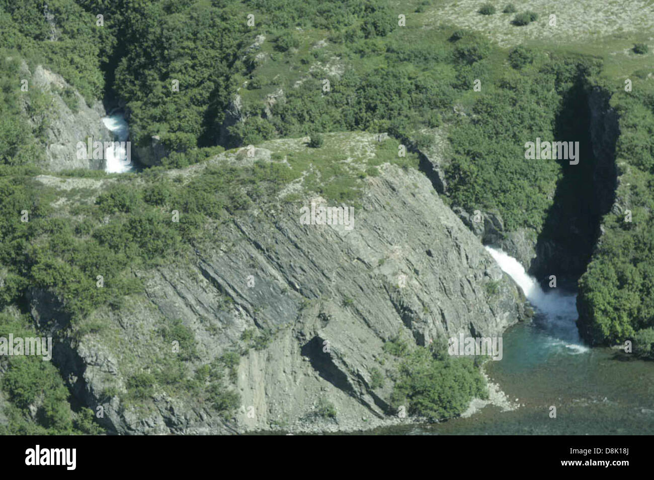 A river flowing through a narrow canyon, with a waterfall tumbling down ...