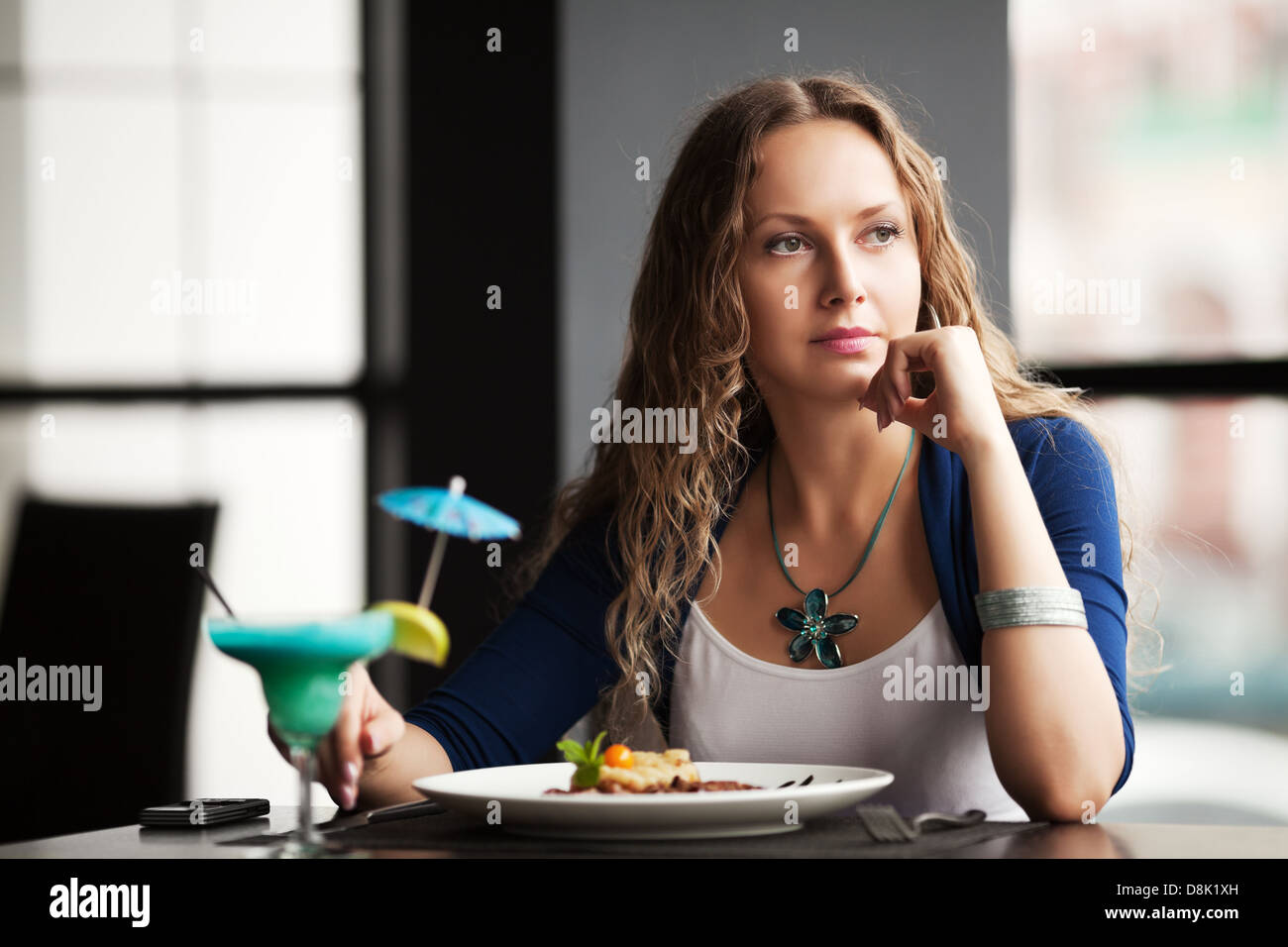 Beautiful young woman dining at a restaurant Stock Photo - Alamy