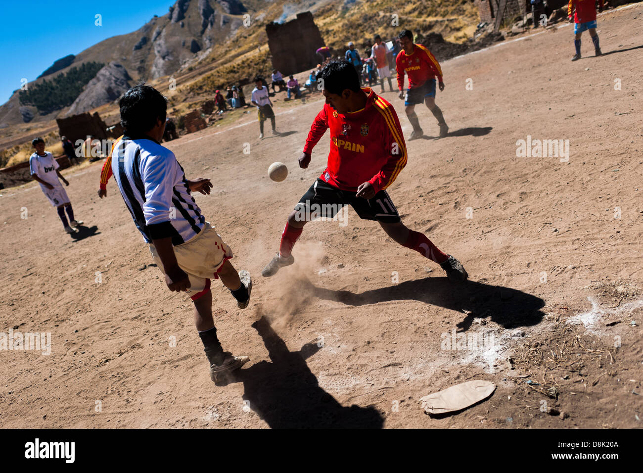 Indigenous men play football on a dirt field in the rural mountain ...