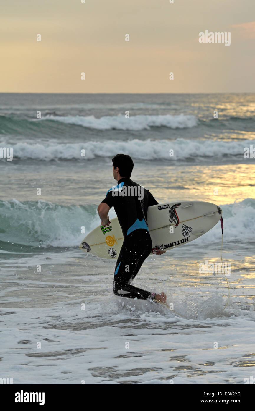 Surfer running into the water at a beach in Mexico Stock Photo - Alamy