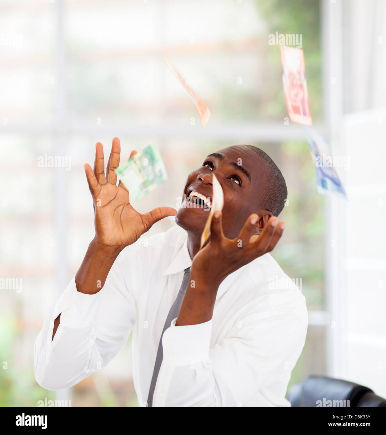 African businessman catching money falling from above Stock Photo - Alamy