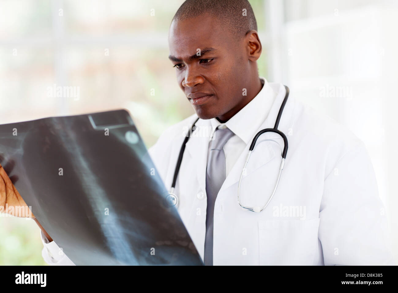 African American doctor looking at patient's x-ray in office Stock ...