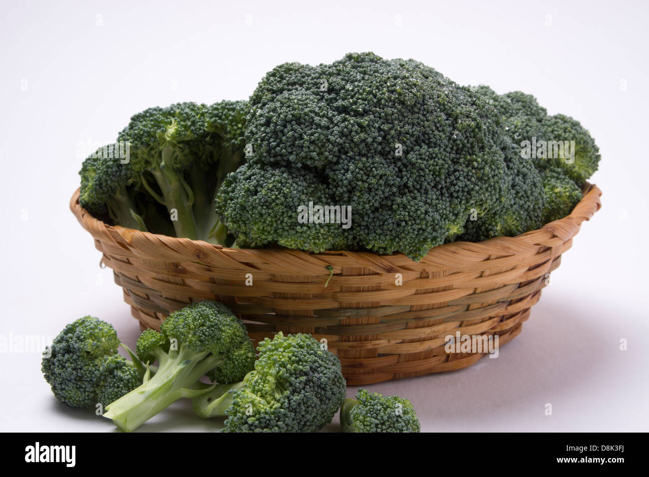 Fresh broccoli in a basket on a white background in a studio setting ...