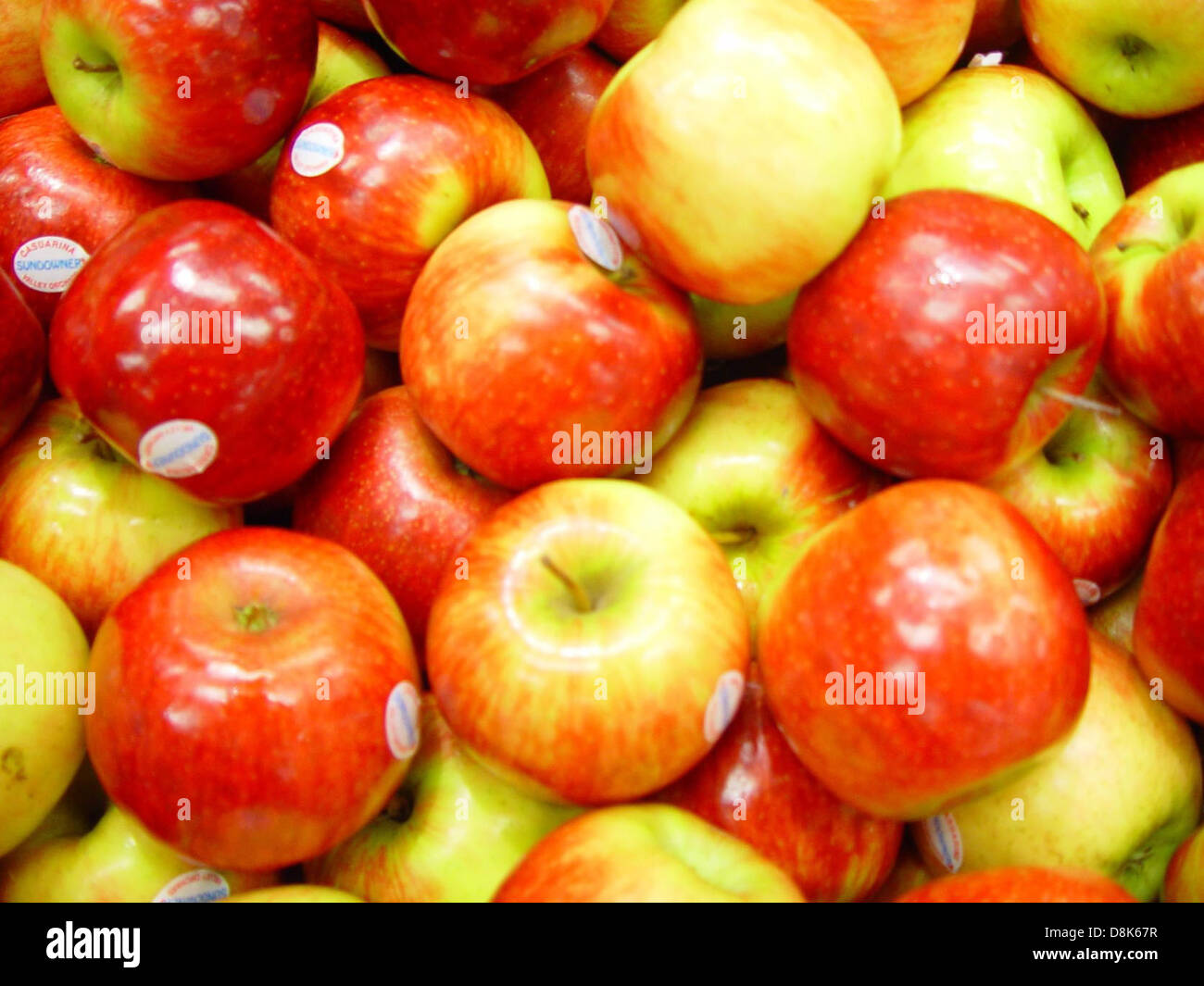 A close-up of shiny red apples, showcasing their vibrant color and ...