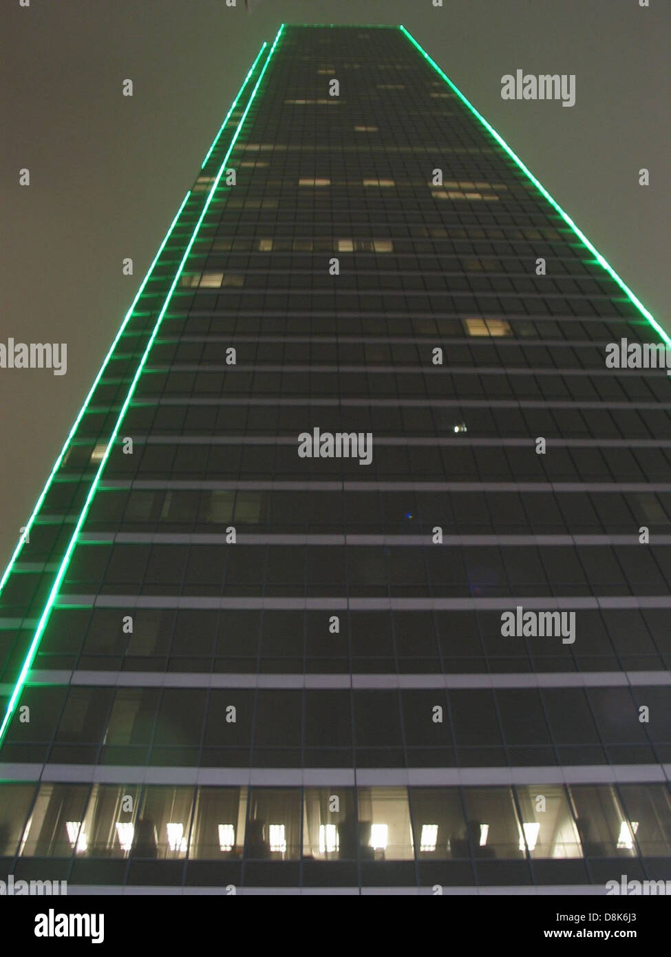 A view of a tall skyscraper illuminated by neon lights in downtown ...