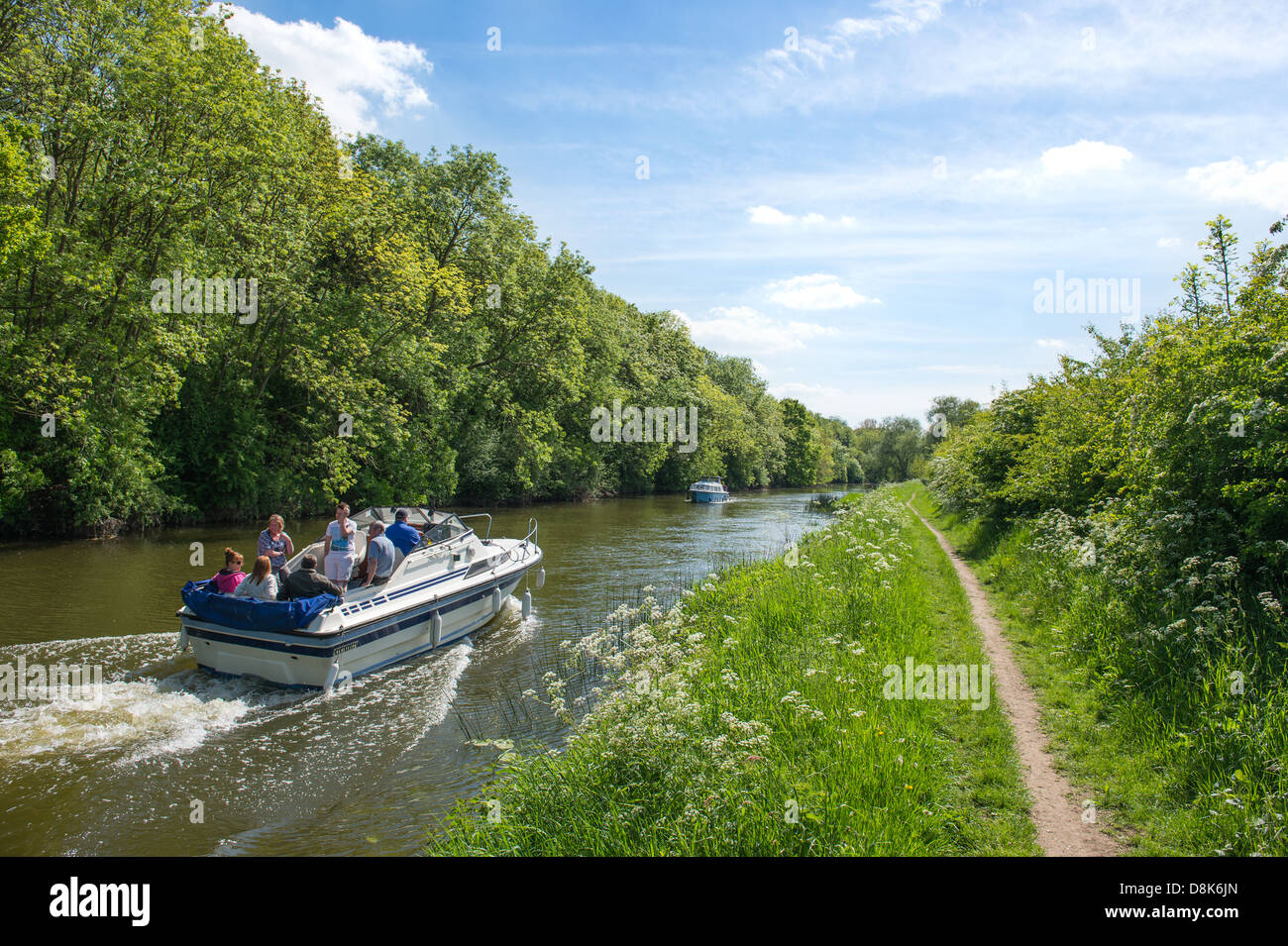 A motor launch close to passing a narrow boat on the River Nene Stock ...