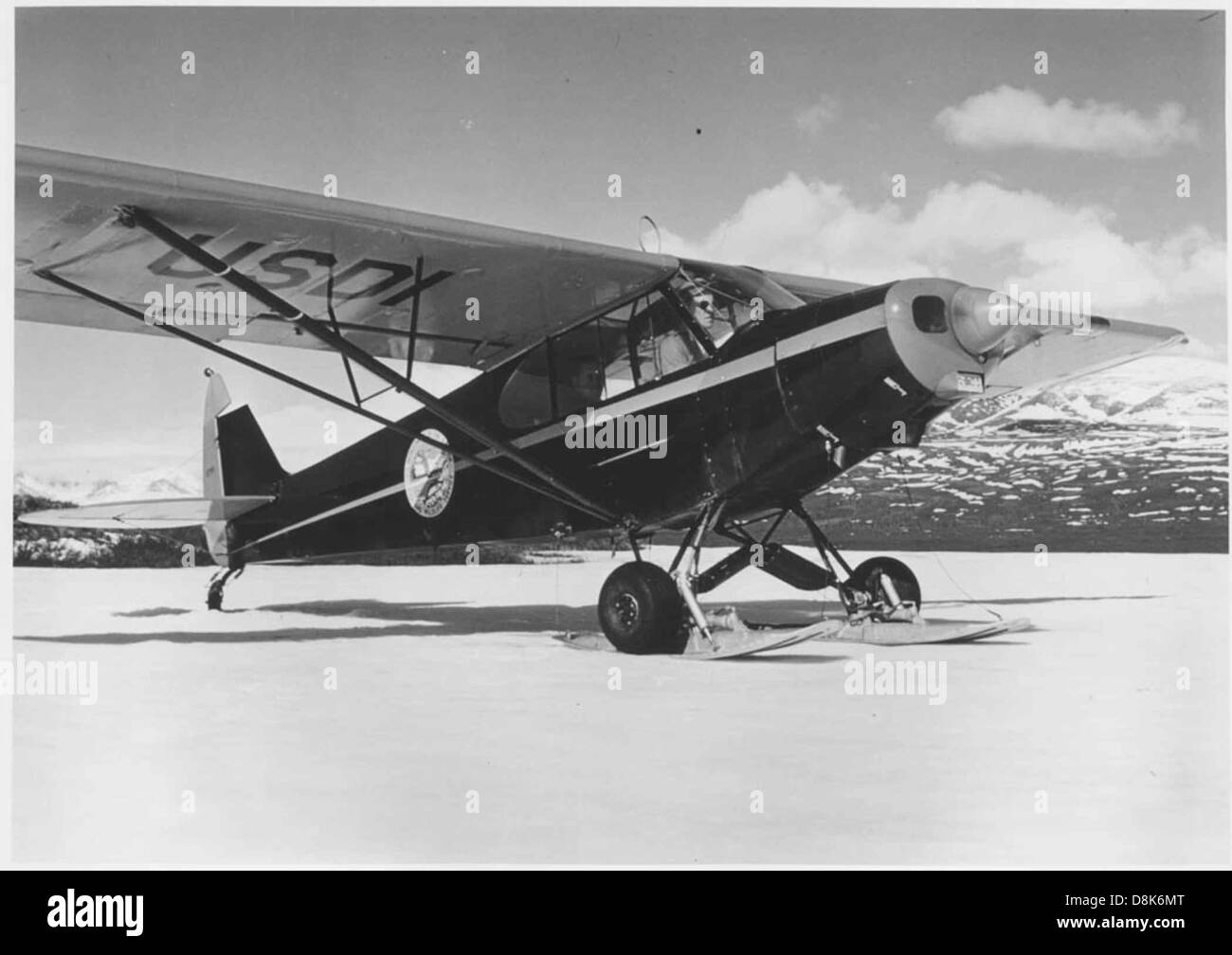 A small airplane fitted with skis is shown on a snowy landscape, ready ...