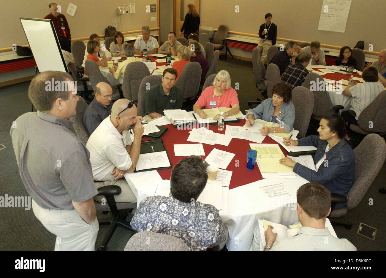 Small groups of professionals working together at tables during a ...
