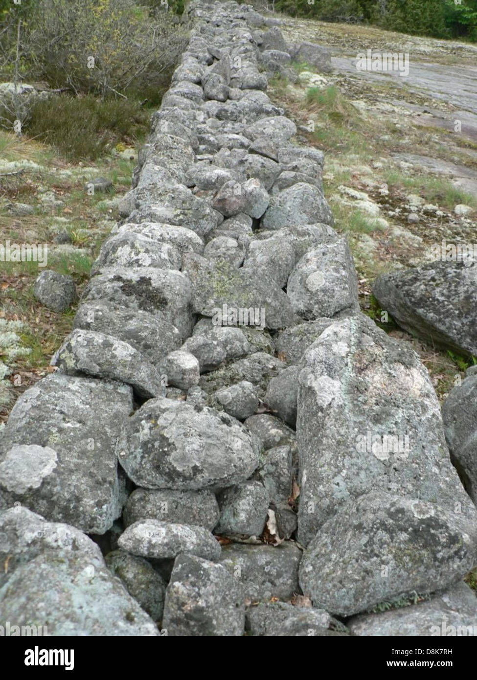 A stone wall, made of natural stones stacked together, forming a ...
