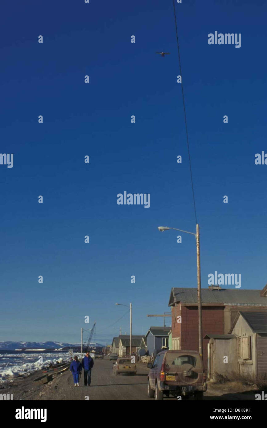 A telephone wire runs across a street, connecting communication systems ...